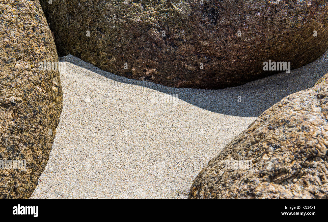Round granite stones in the sand on the beach Stock Photo - Alamy