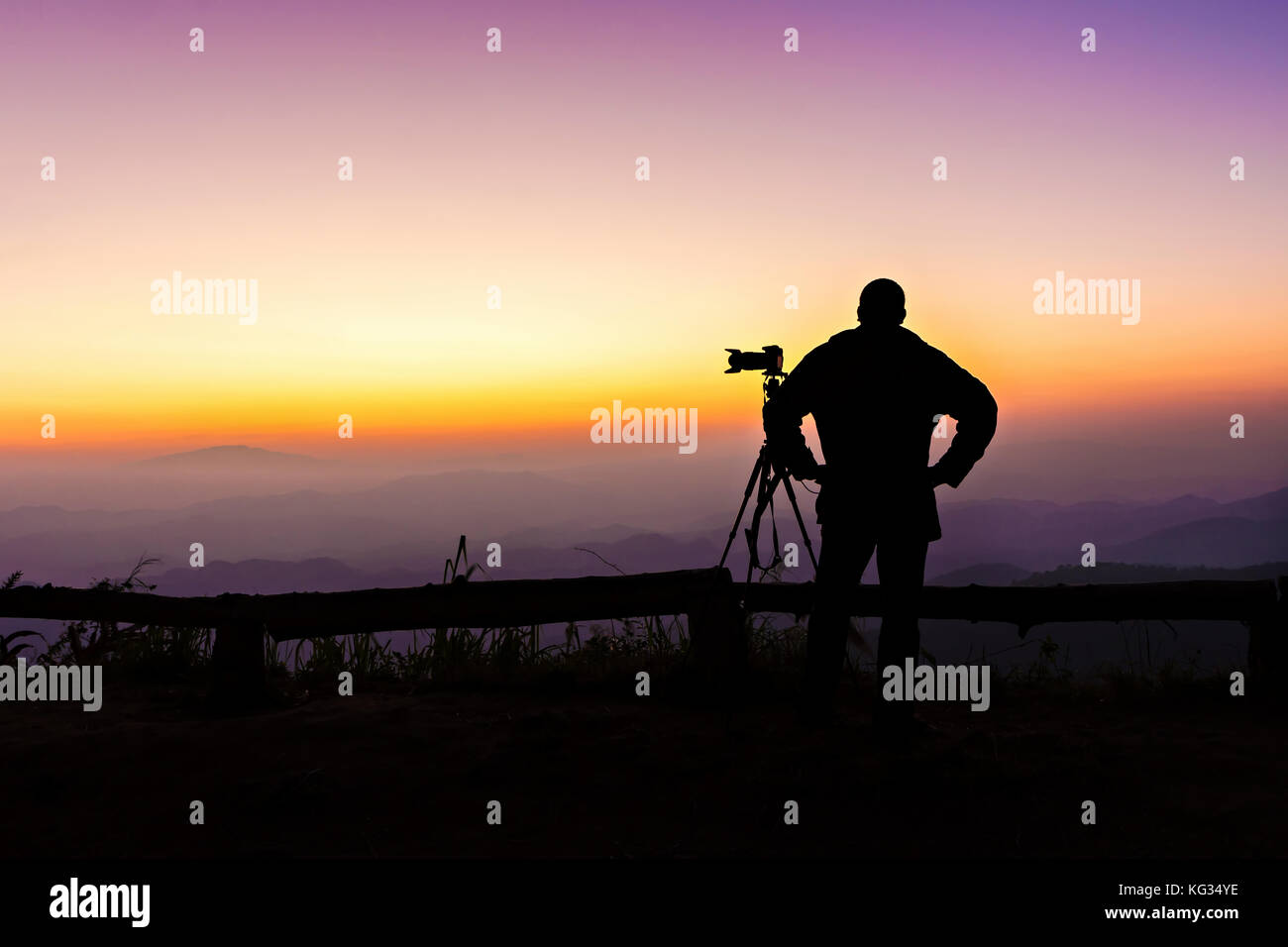 Silhouette of photographer standing at view point in twilight Stock ...