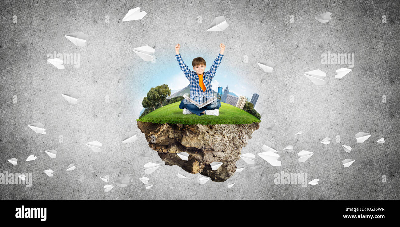 Cute boy of school age with book exploring this great world Stock Photo ...