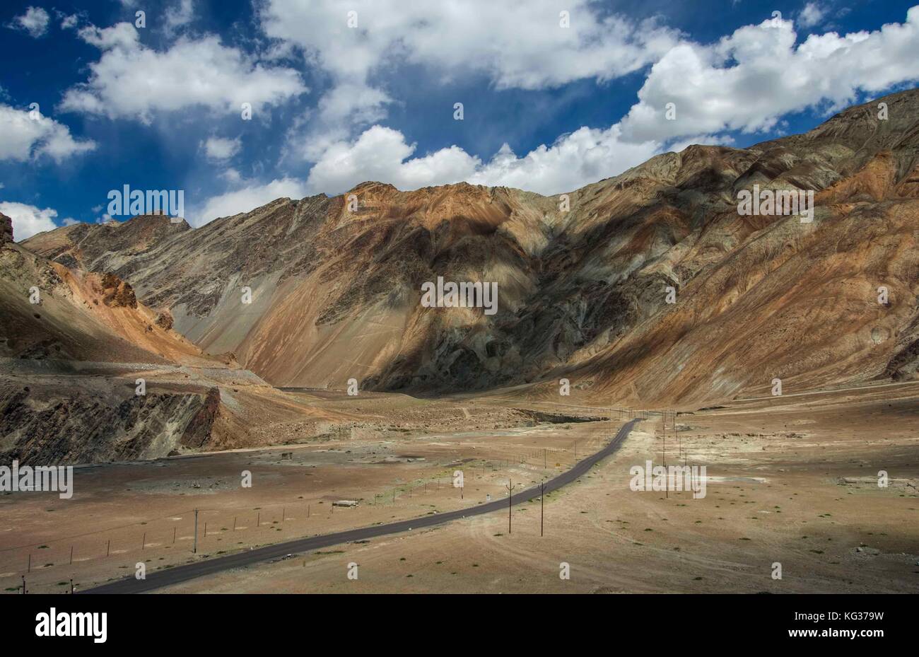 Mountain road: gray asphalt tape stretches along the valley of a wide ...