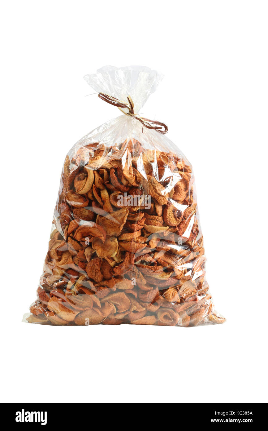 Dried pieces of apples in a transparent bag tied with ribbon isolated ...