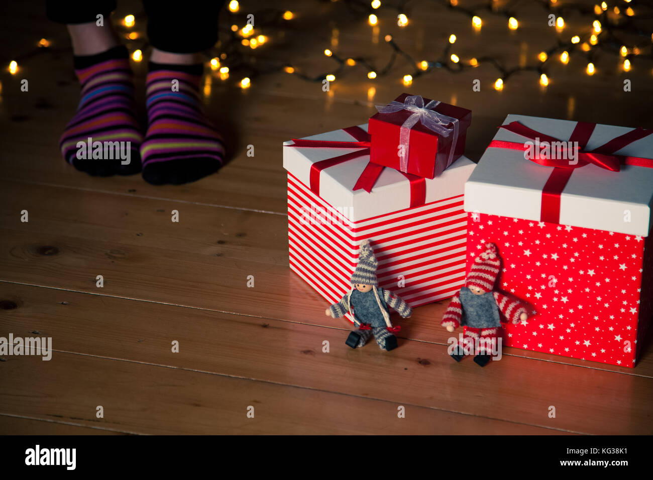 red gift boxes feet and christmas lights on wooden floor Stock Photo ...