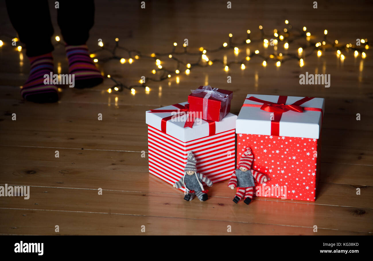 red gift boxes feet and christmas lights on wooden floor Stock Photo ...