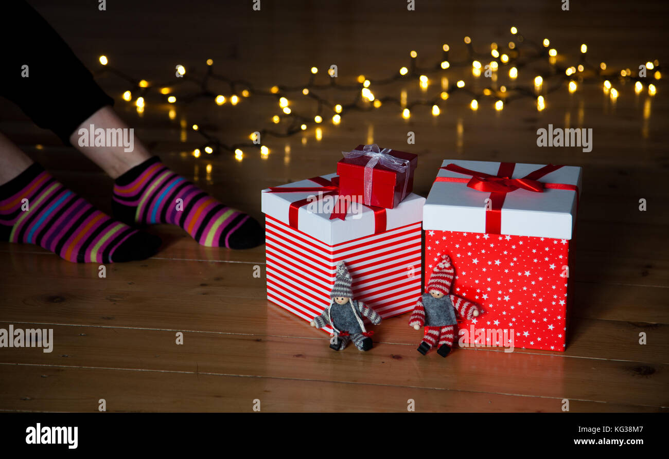 red gift boxes feet and christmas lights on wooden floor Stock Photo ...