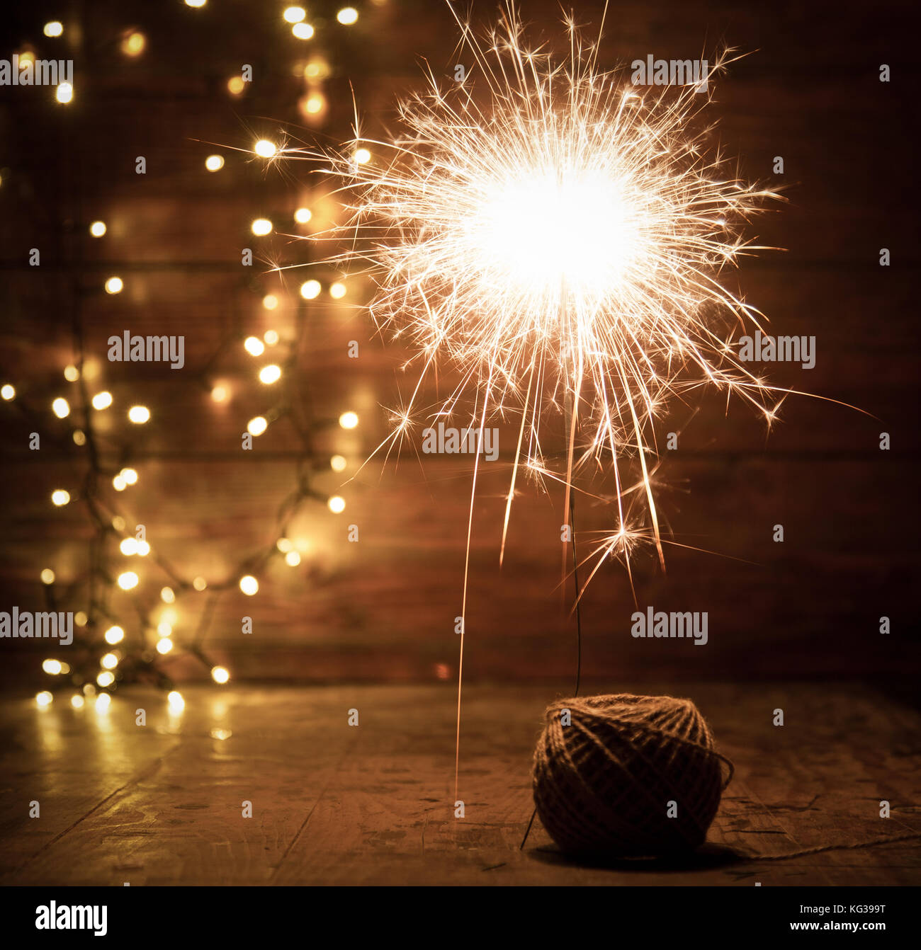 burning sparkler and christmas lights on wooden background Stock Photo ...