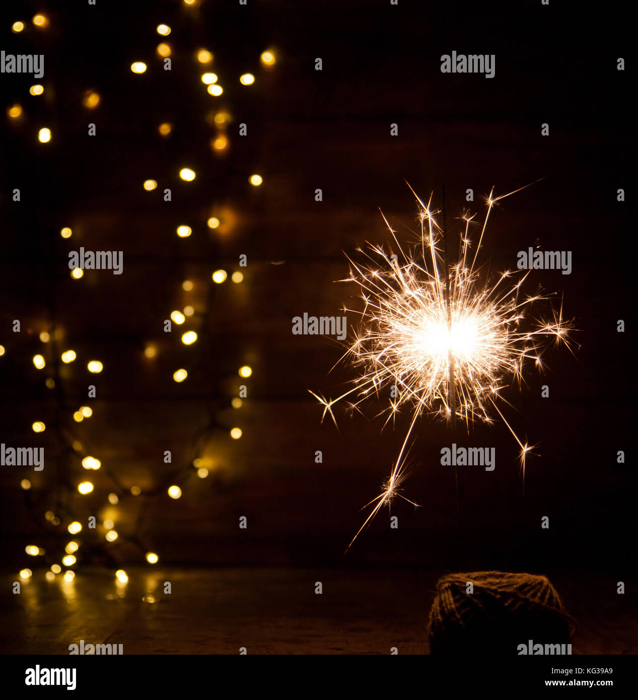 burning sparkler and christmas lights on wooden background Stock Photo ...