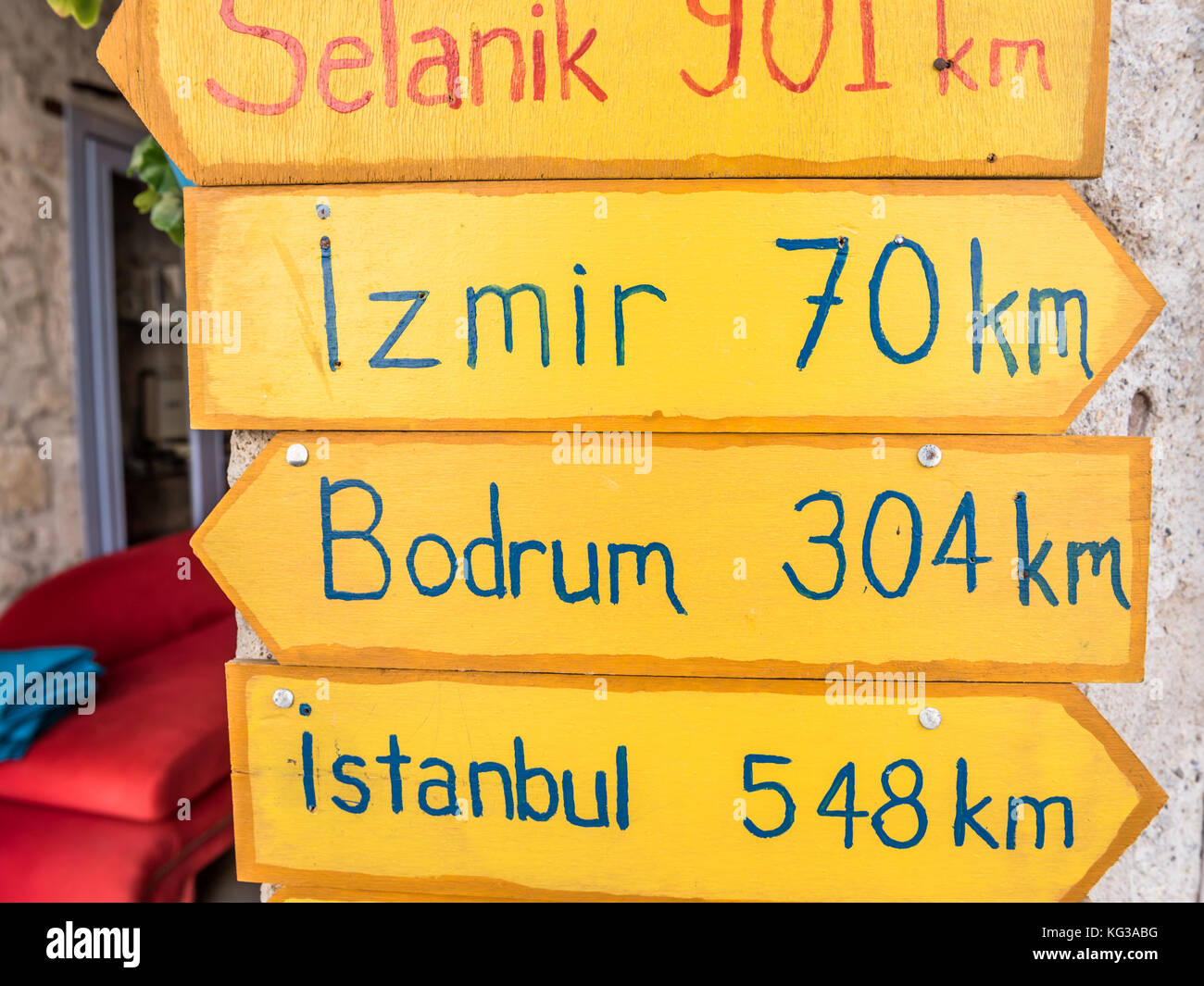 A wooden orange sign post showing distances, in Kilometers, to some of ...