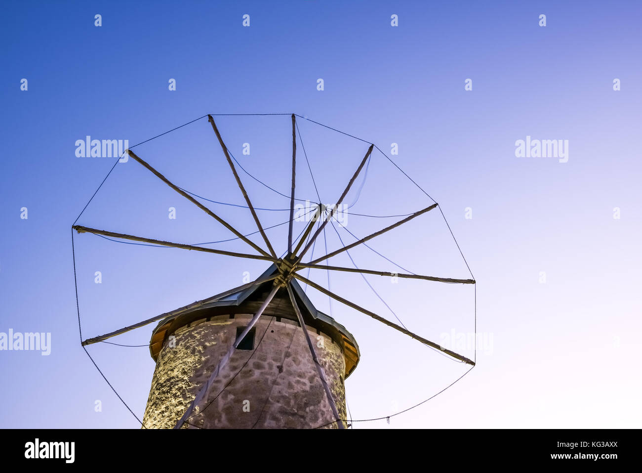 Close detailed night view of ancient stone windmill on clean blue sky ...
