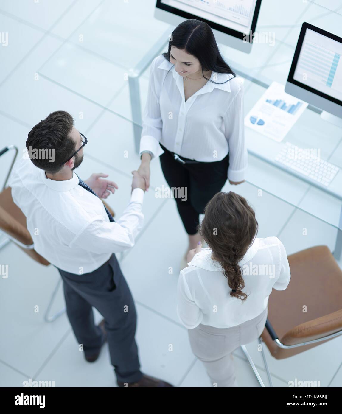 handshake manager and employee near the workplace. photo with copy ...