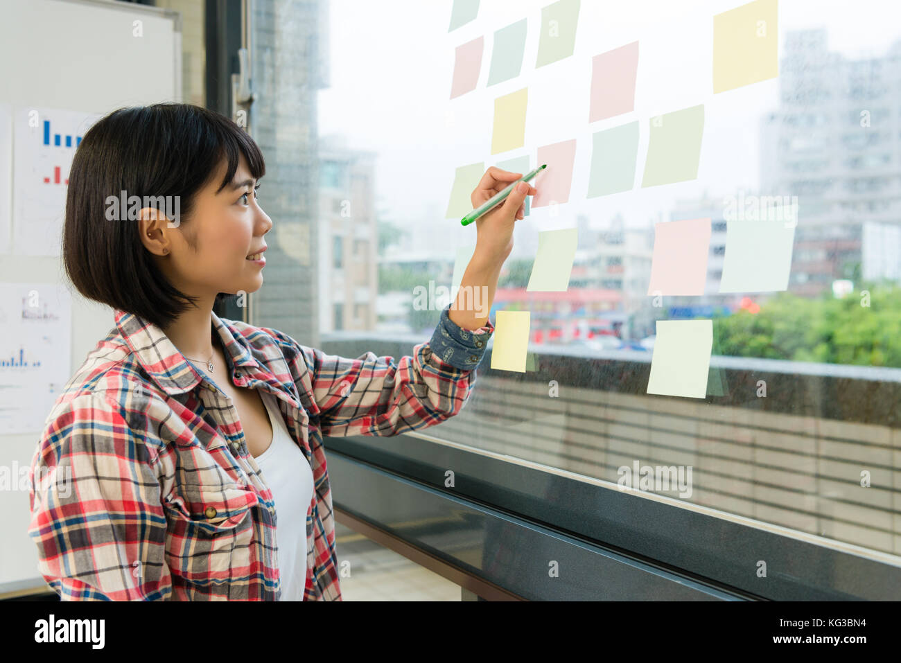 pretty attractive business woman standing in front of glass wall ...