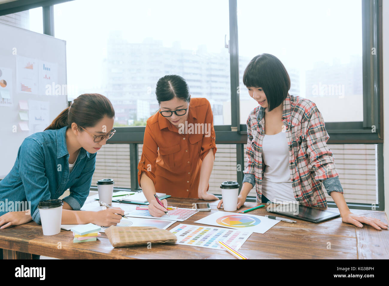 elegant attractive female designer team leader pointing color paper for ...