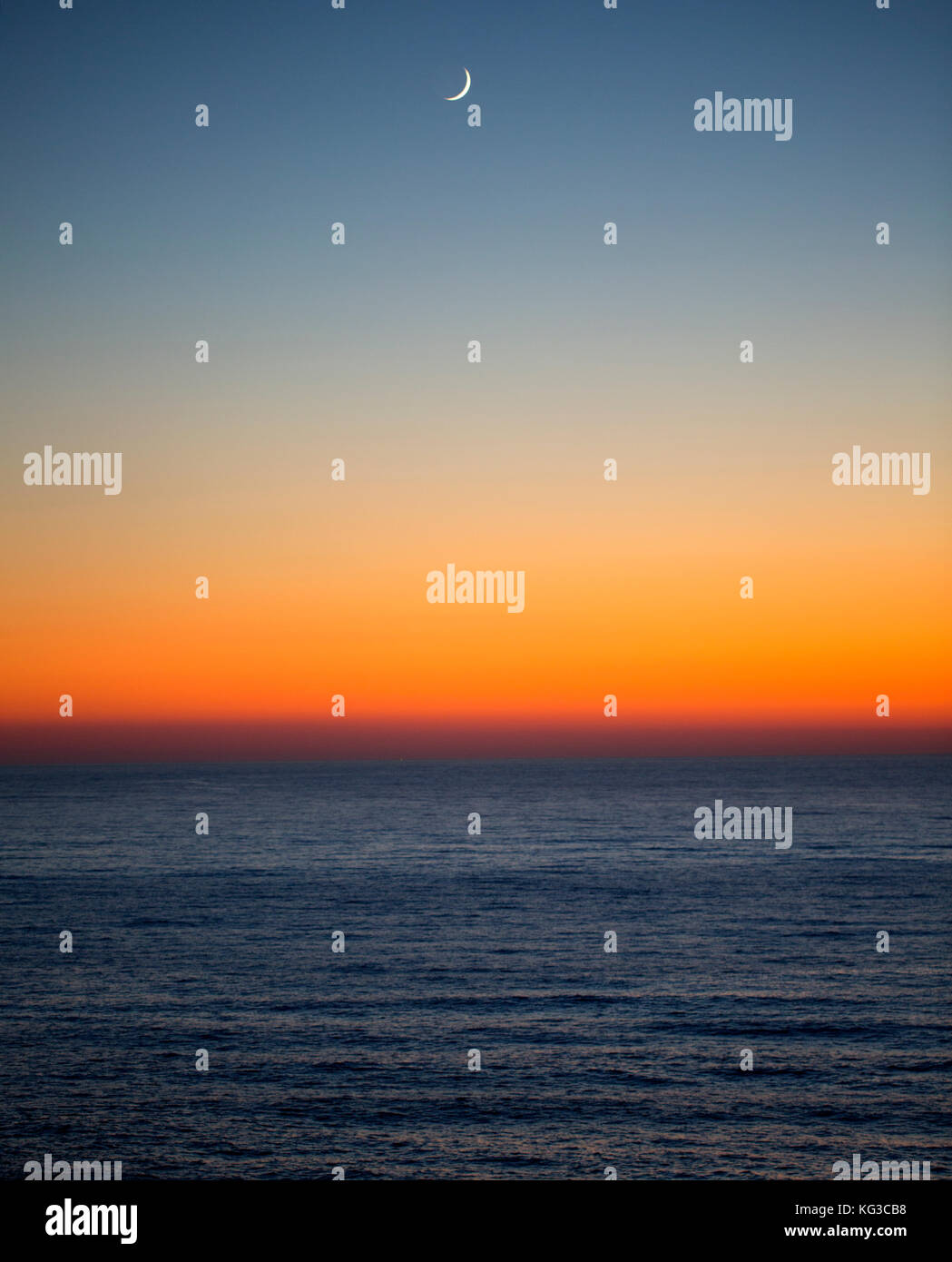 sunset on the sea with new moon Stock Photo - Alamy