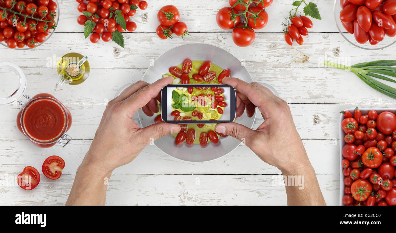 hands taking photo of food with the smartphone from above saucepan and ...