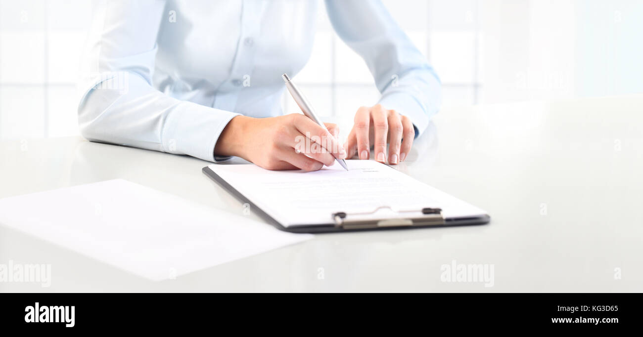 Woman's hands writing on sheet in a clipboard with a pen, isolated on ...