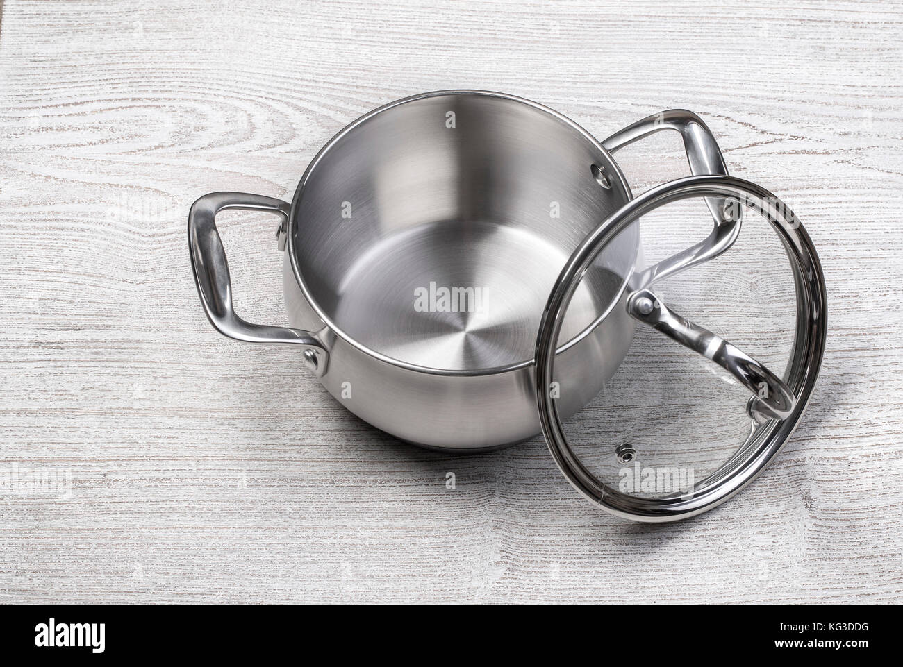 Open stainless steel cooking pot on white wooden table Stock Photo - Alamy