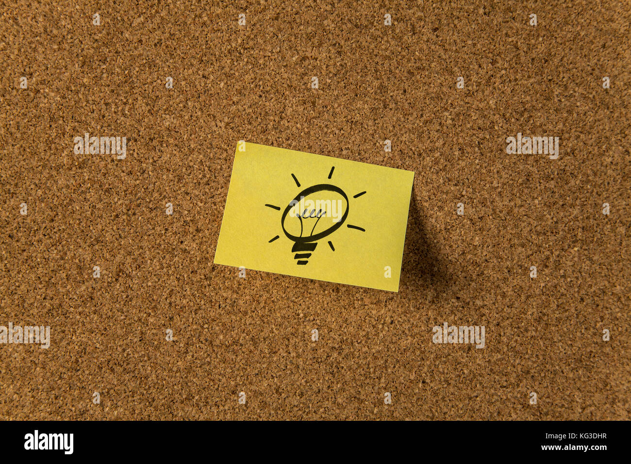 Yellow sticky note with drawing light bulb on the cork board Stock ...