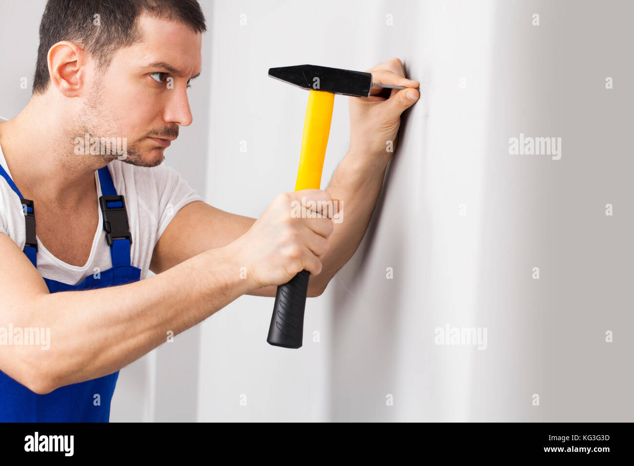 Man fixing nail with hammer Stock Photo - Alamy
