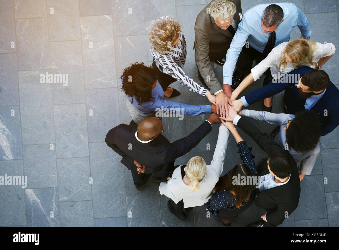 High angle view of a team of united coworkers standing with their hands ...