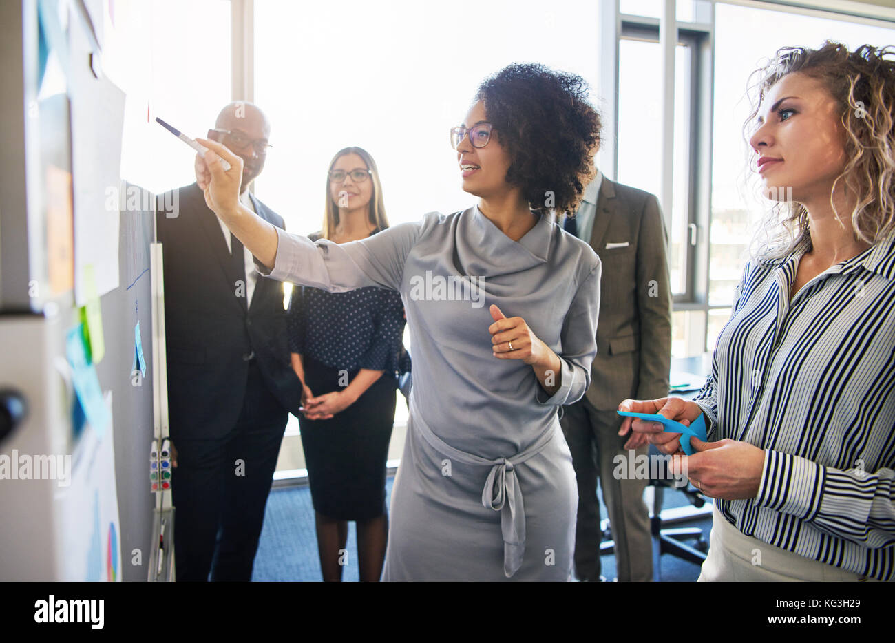 Diverse group of focused businesspeople brainstorming together on a ...