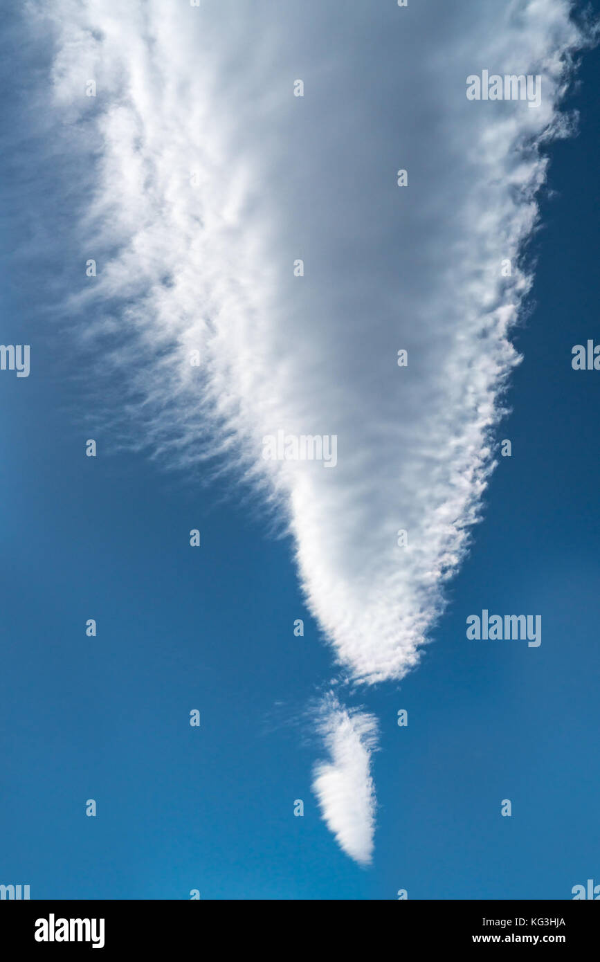 Long arrow shaped cloud against a bright blue sky Stock Photo - Alamy