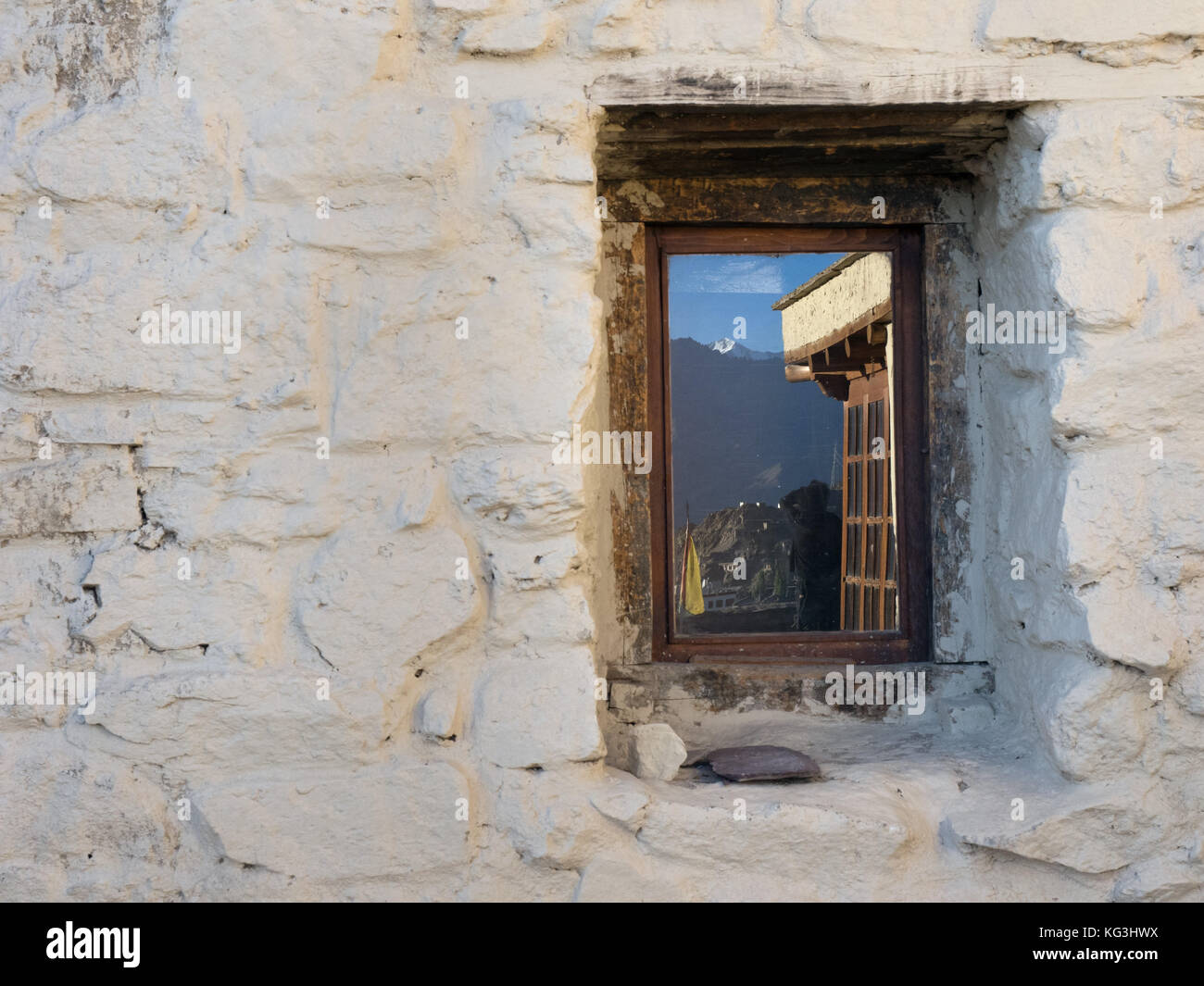 Old brick white wall of the Buddhist monastery with a small rectangular ...