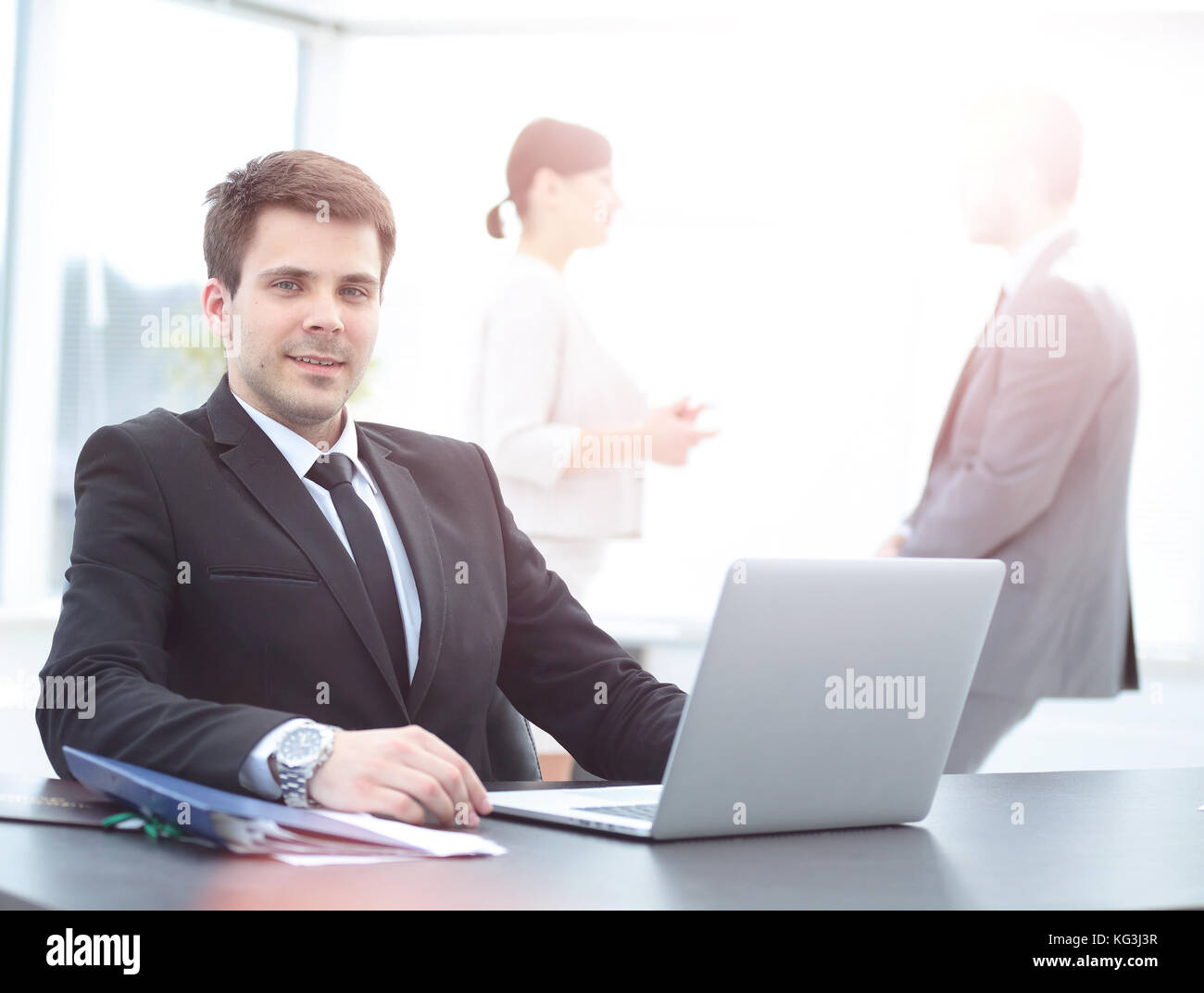 successful businessman sitting behind a Desk with an open laptop Stock ...
