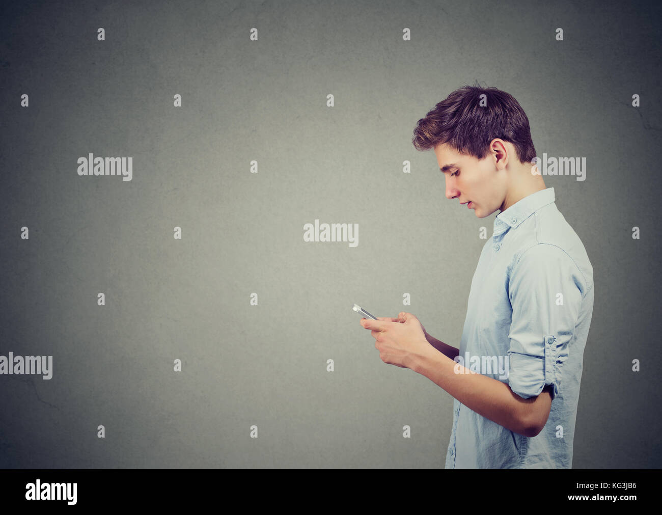 Side profile of a handsome guy using a smartphone Stock Photo - Alamy