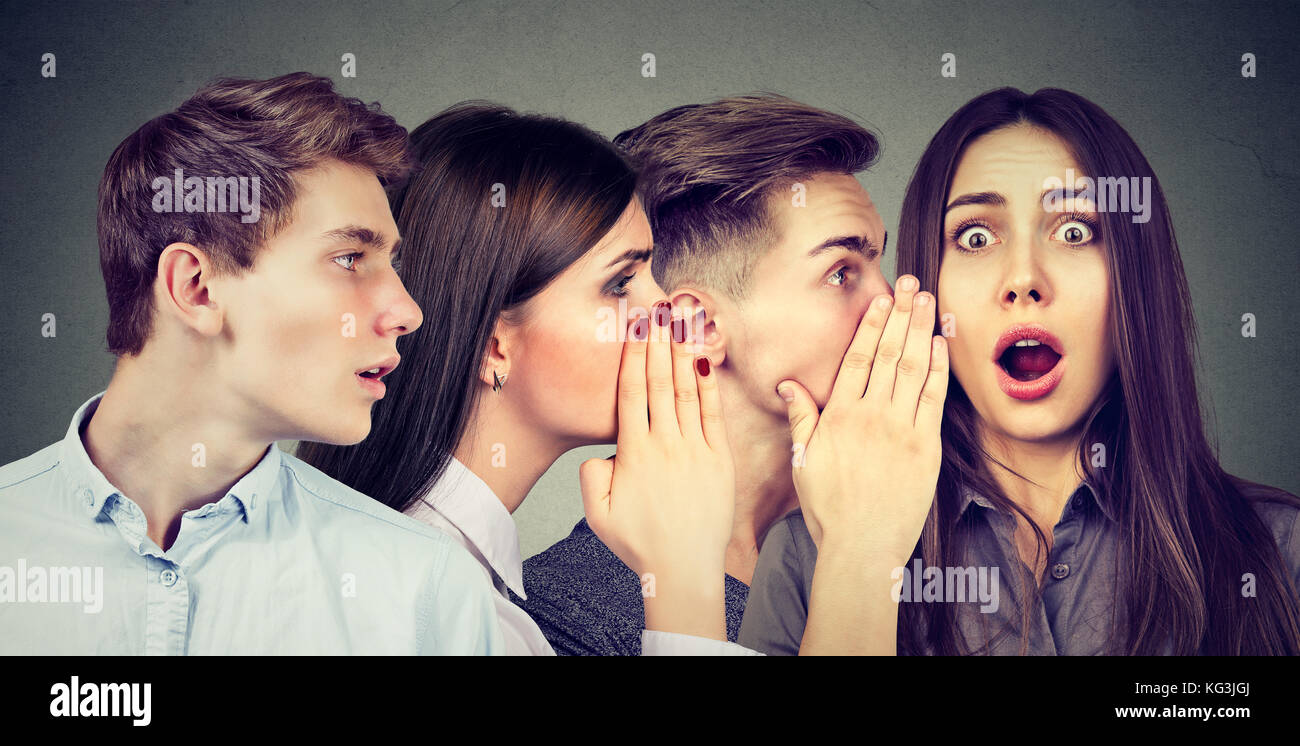 Group of young people men and women whispering each other in the ear ...