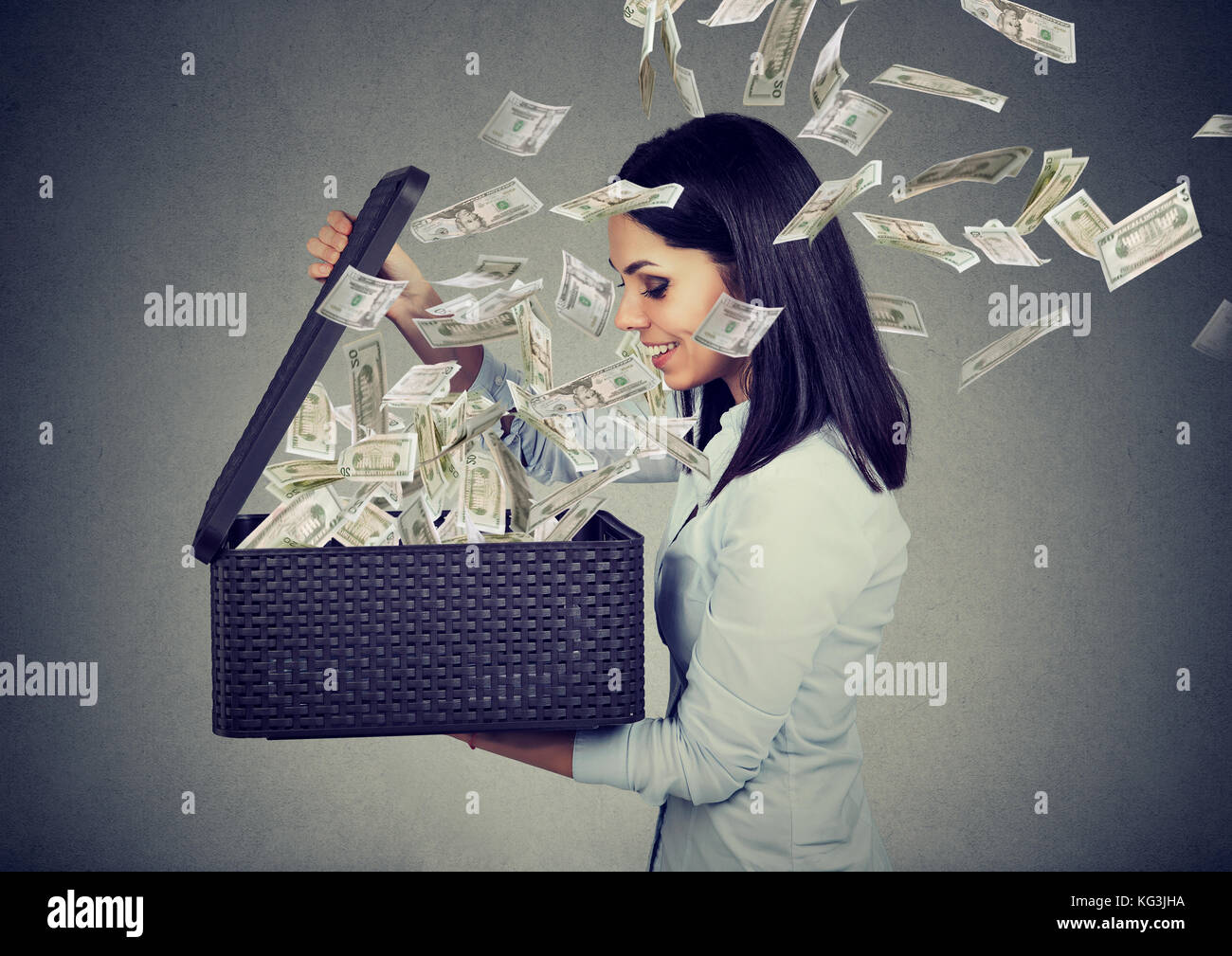 Woman opening a box with money flying out away Stock Photo - Alamy
