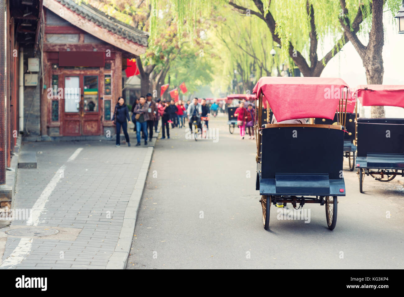 Tourists riding Beijing traditional rickshaw in old China Hutongs in ...