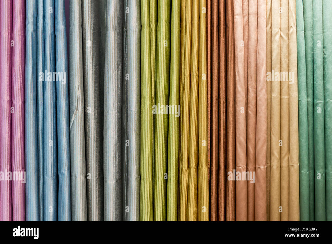 Colorful curtain samples hanging from hangers on a rail in a display in ...