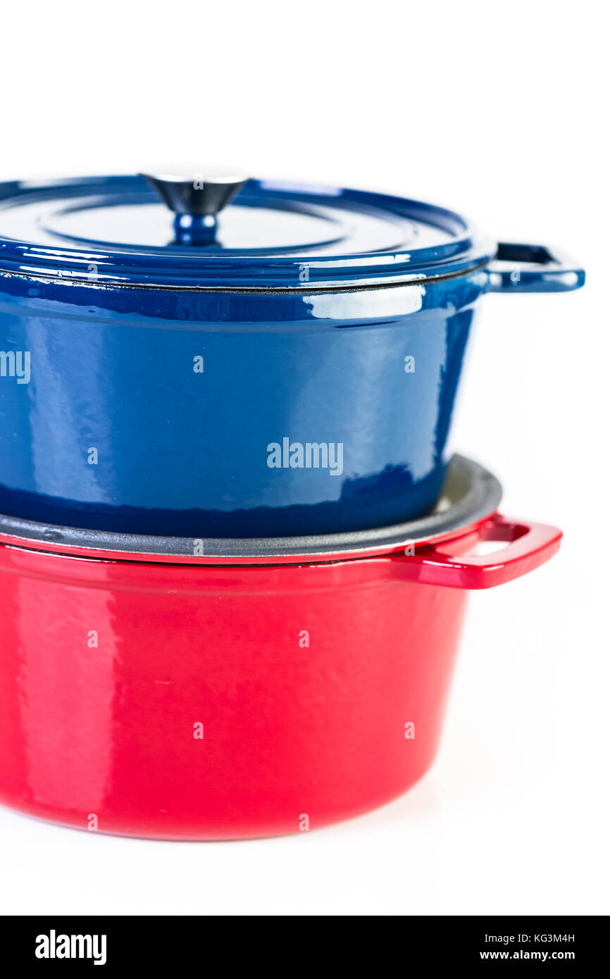 Red and blue enameled cast iron covered dutch ovens on a white ...