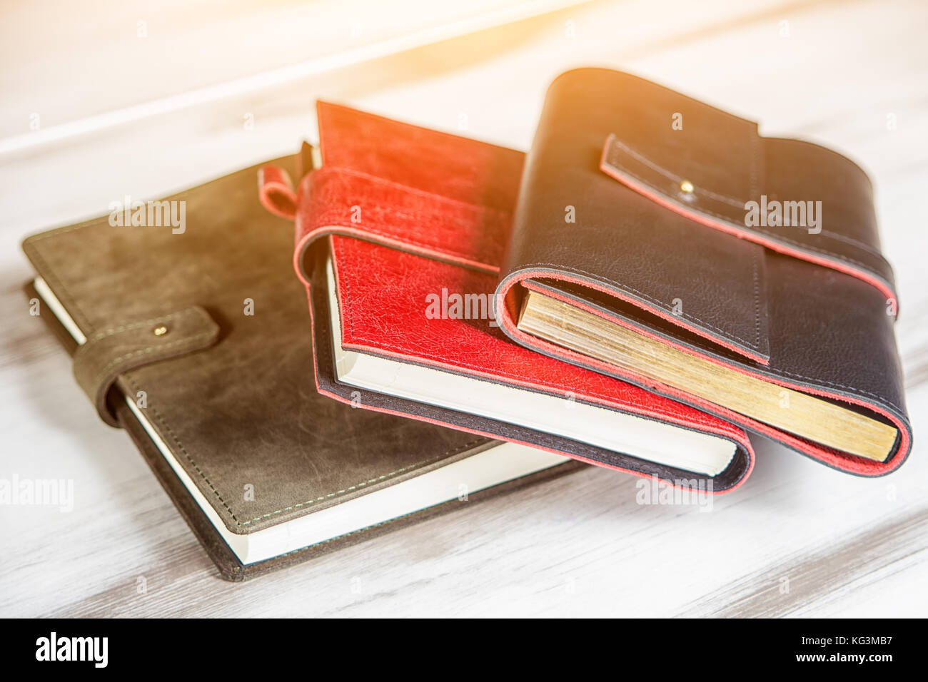 A close-up of three diaries, covered with genuine leather with a clasp ...