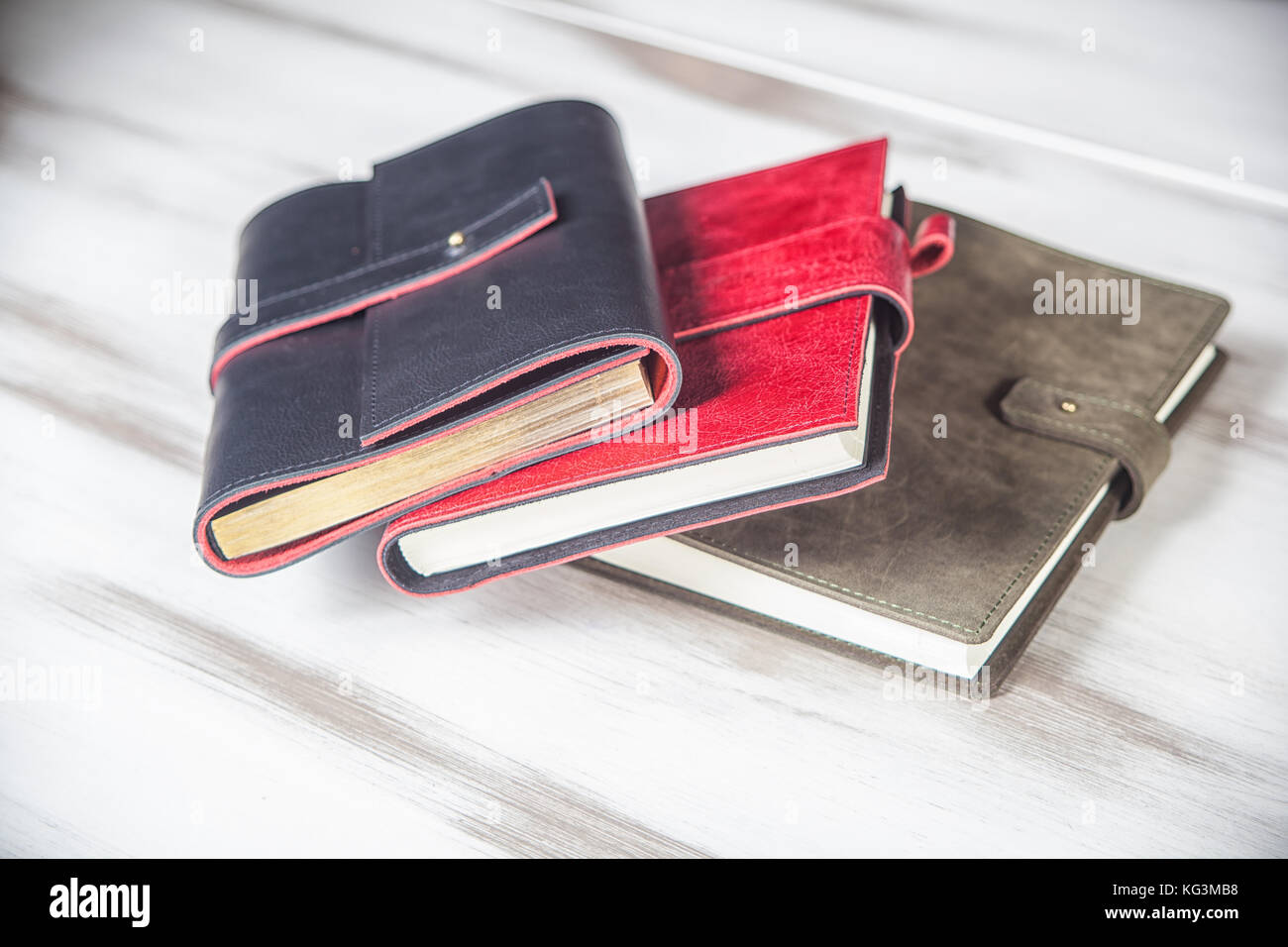 A close-up of three diaries, covered with genuine leather with a clasp ...