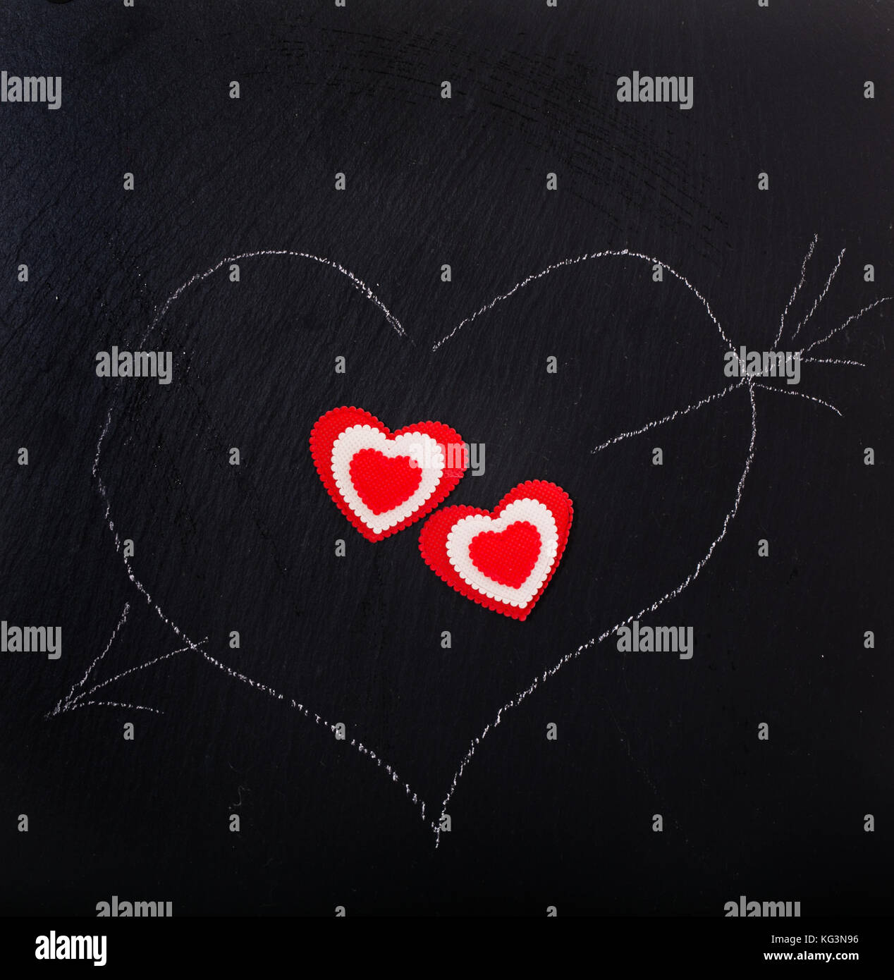 The heart drawn with chalk. The drawing on a black board, red hearts ...