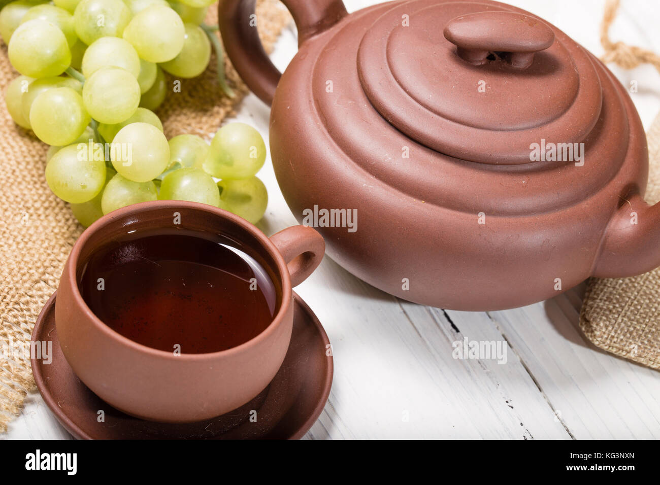 Cluster of grapes and clay cup with tea. Close up, top view Stock Photo ...