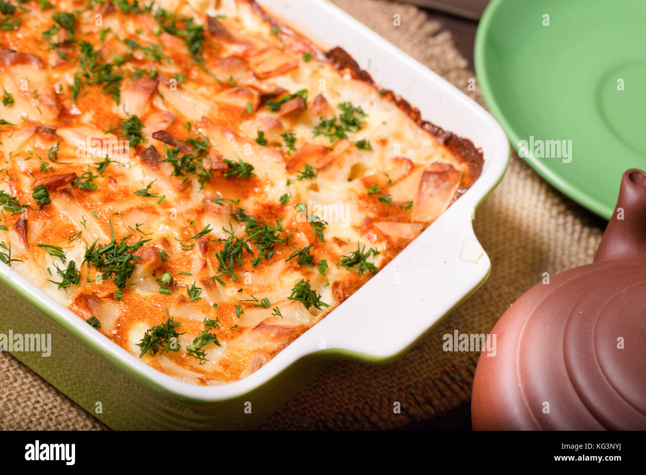 Dish with the baked potatoes on a kitchen table. The close up, toasted ...