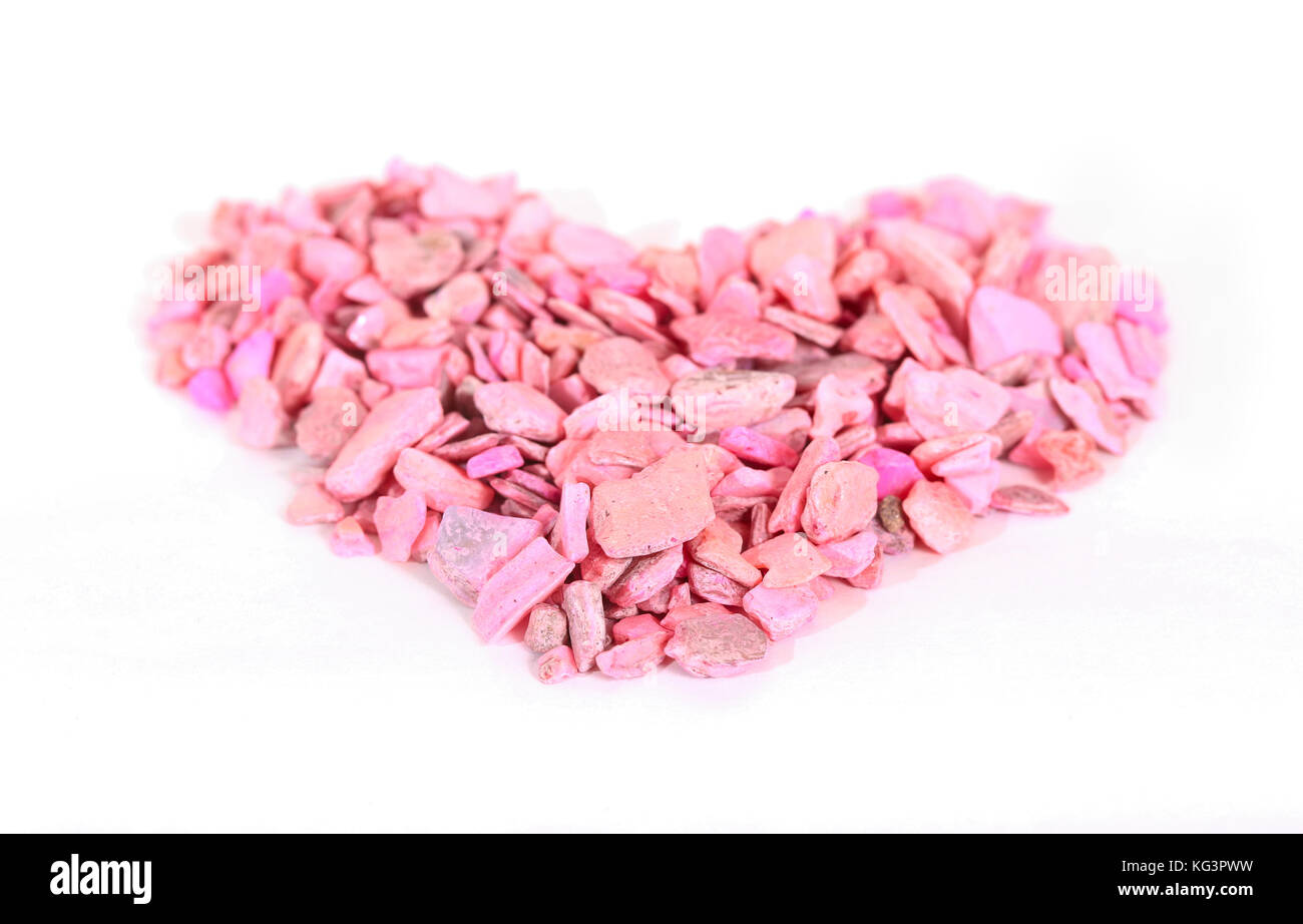 Heart from pink stones on white boards. The heart is laid out from ...
