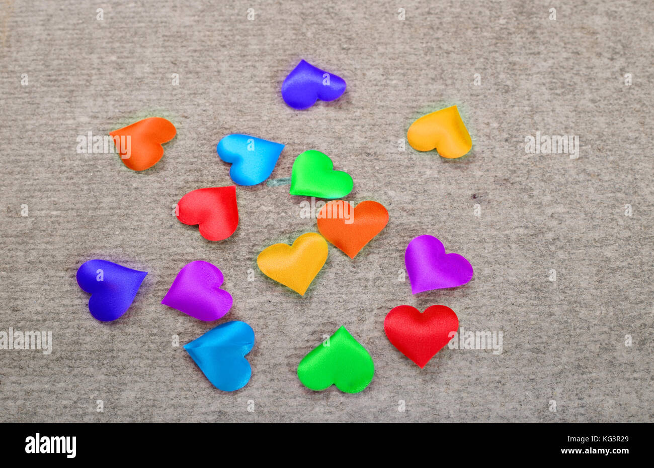 Sprectrum multi-colored hearts on a gray background. A scattering of ...