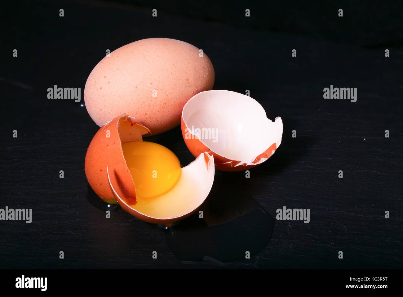 The broken egg against a dark background. Two eggs, a single whole, the ...