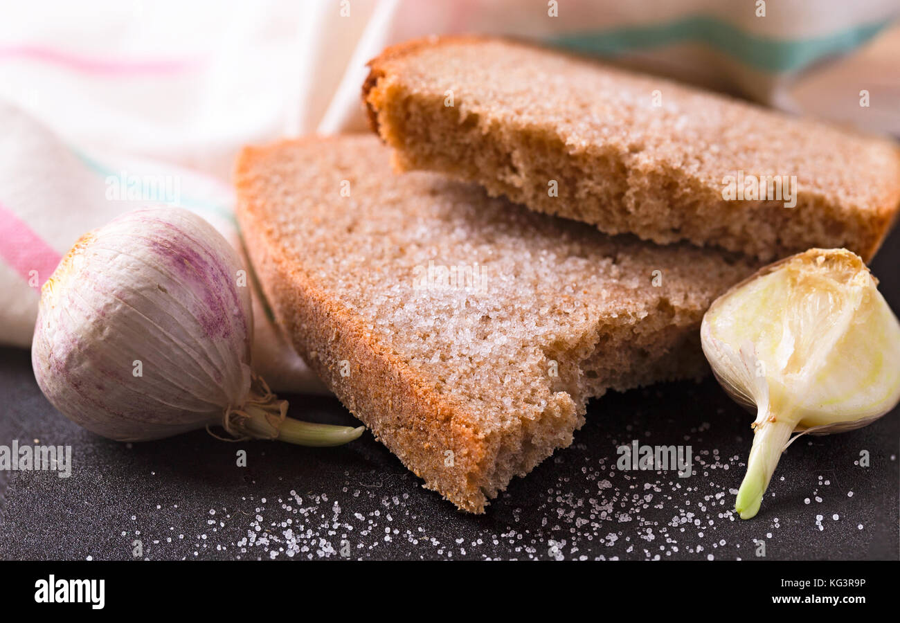 The garlic and rye bread salted. A close up, a kitchen towel on a ...