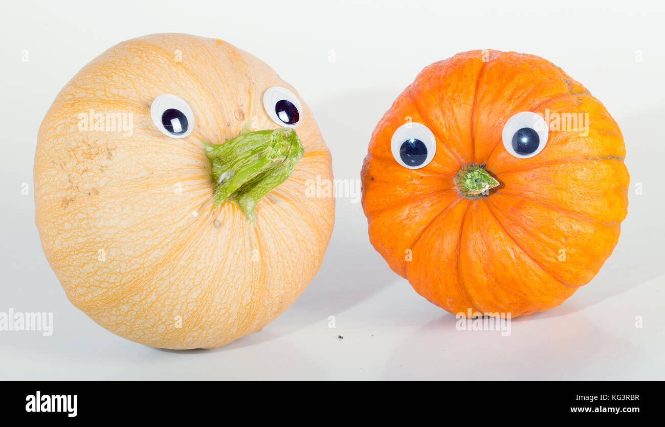 Two ripe pumpkins with eyes. White background Stock Photo - Alamy