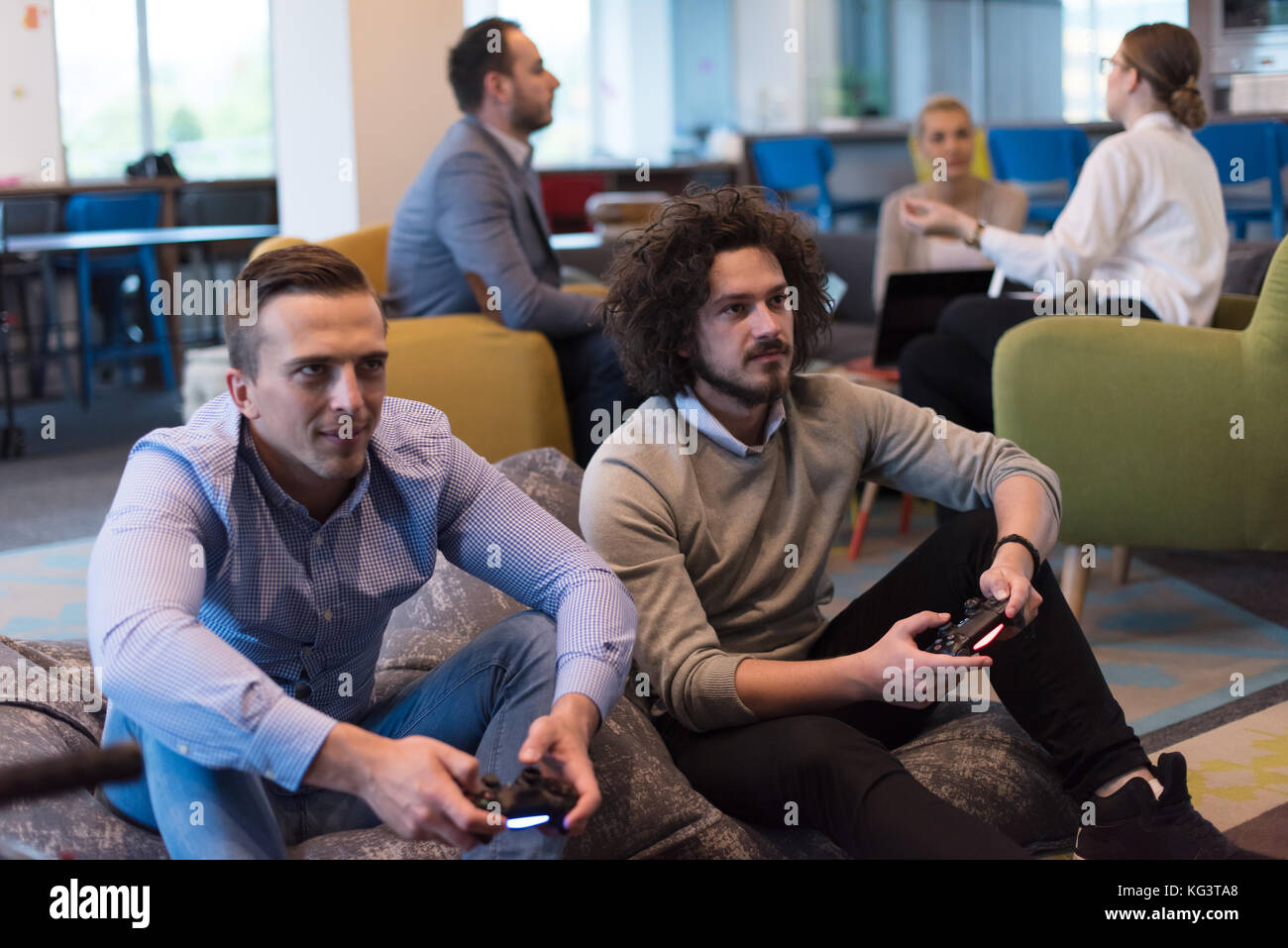 Work hard play hard. Workers Playing computer games in creative startup ...