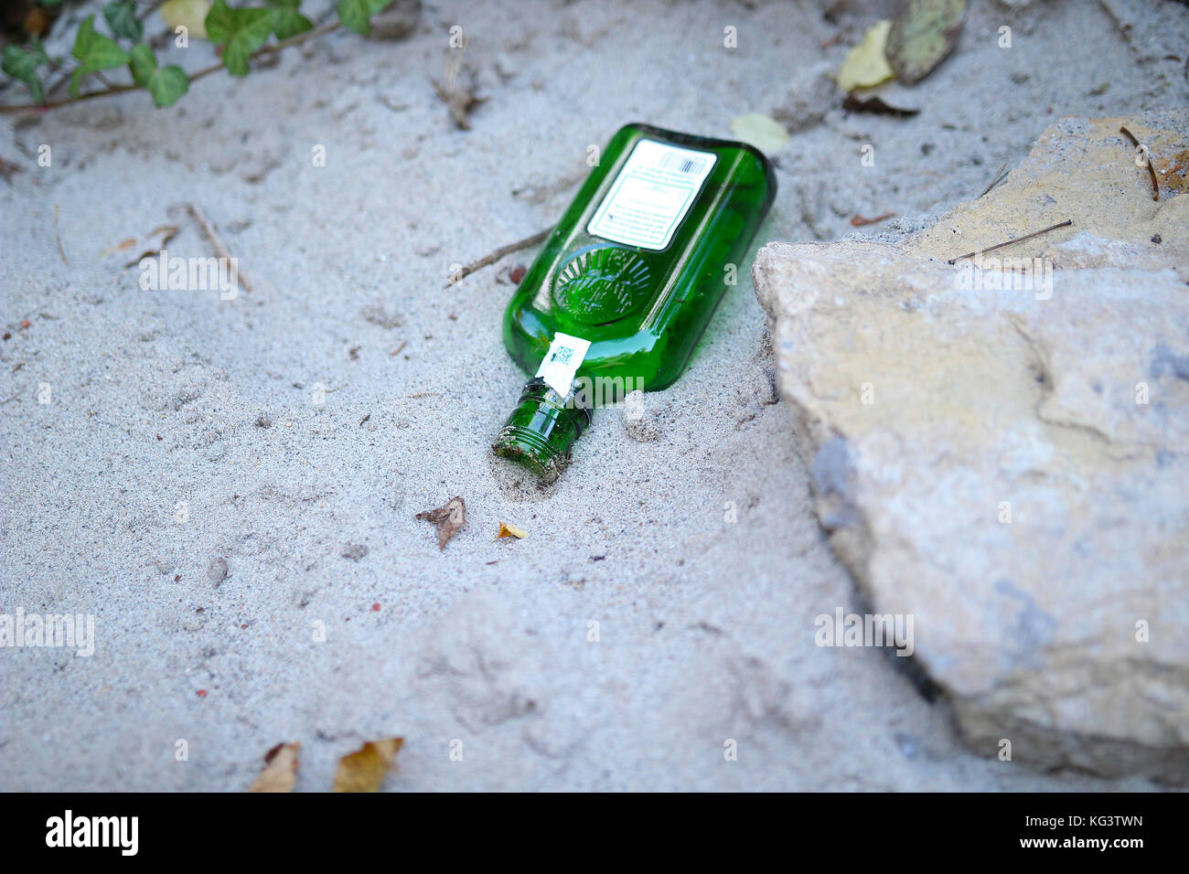 Dirty beach. Alcohol bottle on the beach sand. Sea pollution Stock ...