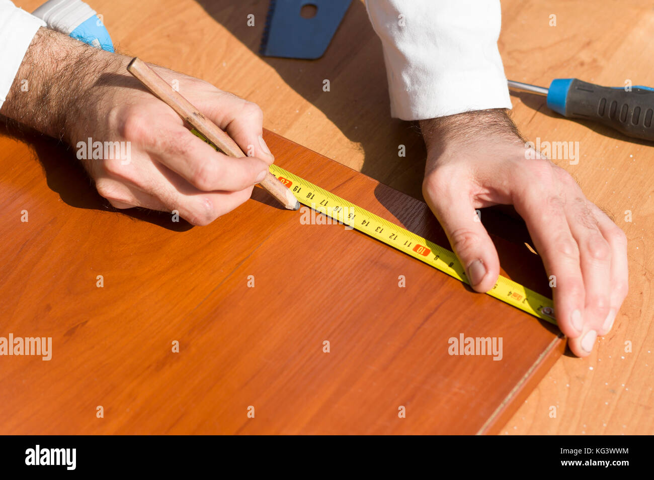 The carpenter measures the distance using a measure and marks with a ...