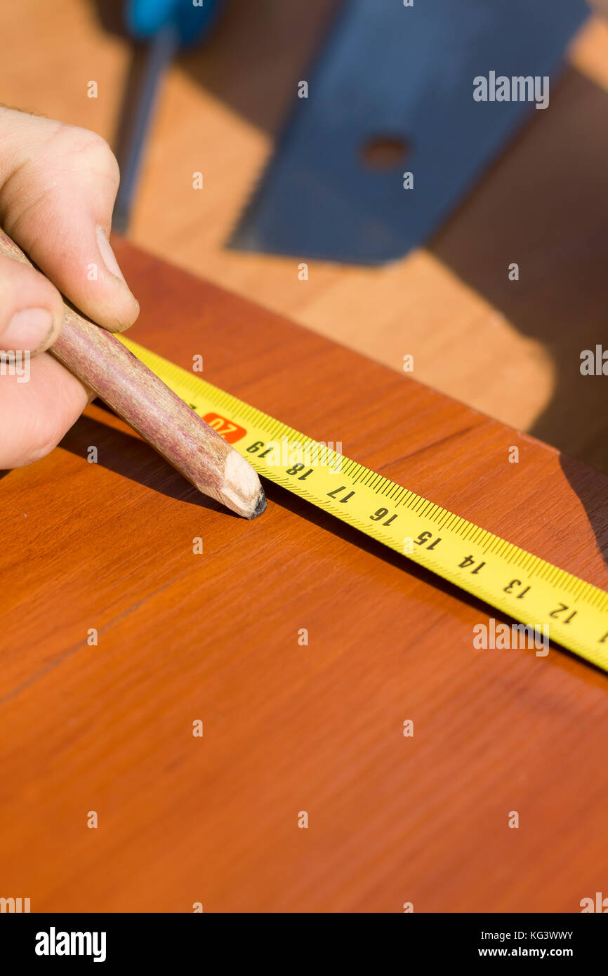 The carpenter measures the distance using a measure and marks with a ...