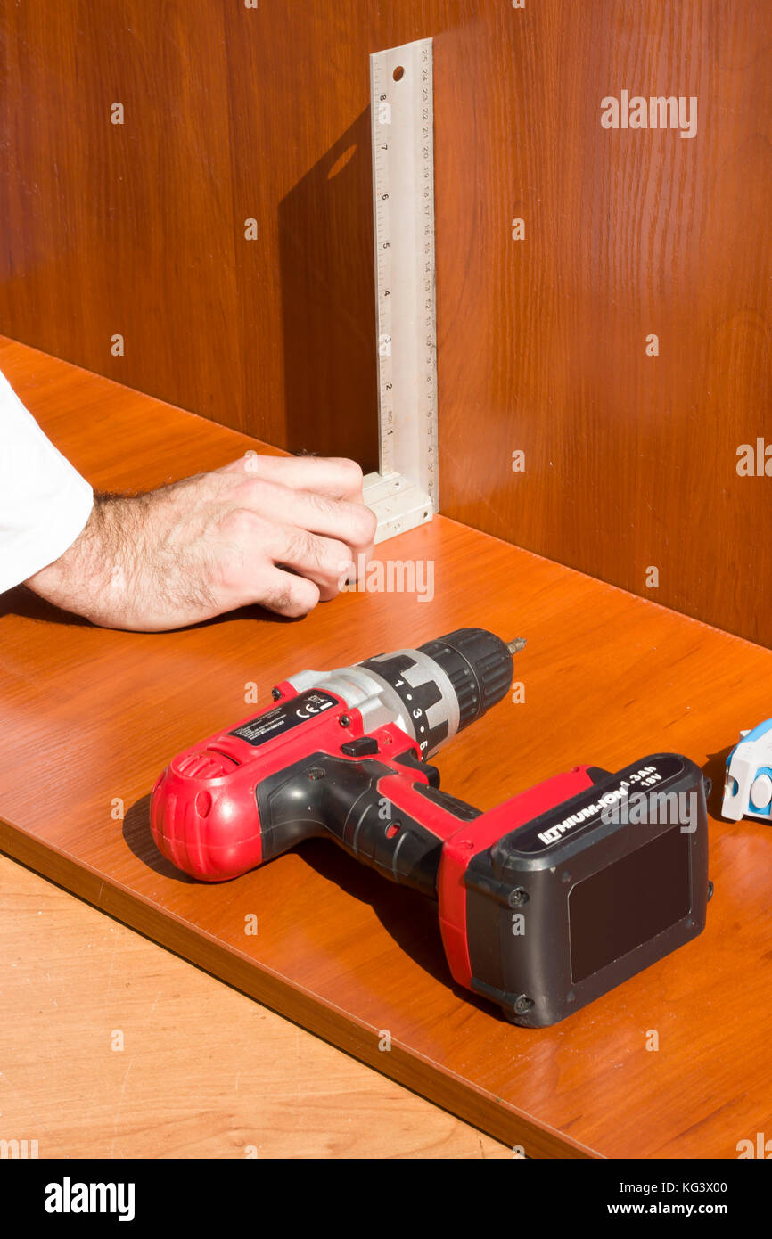 The carpenter checks the angle of joining the furniture boards using ...