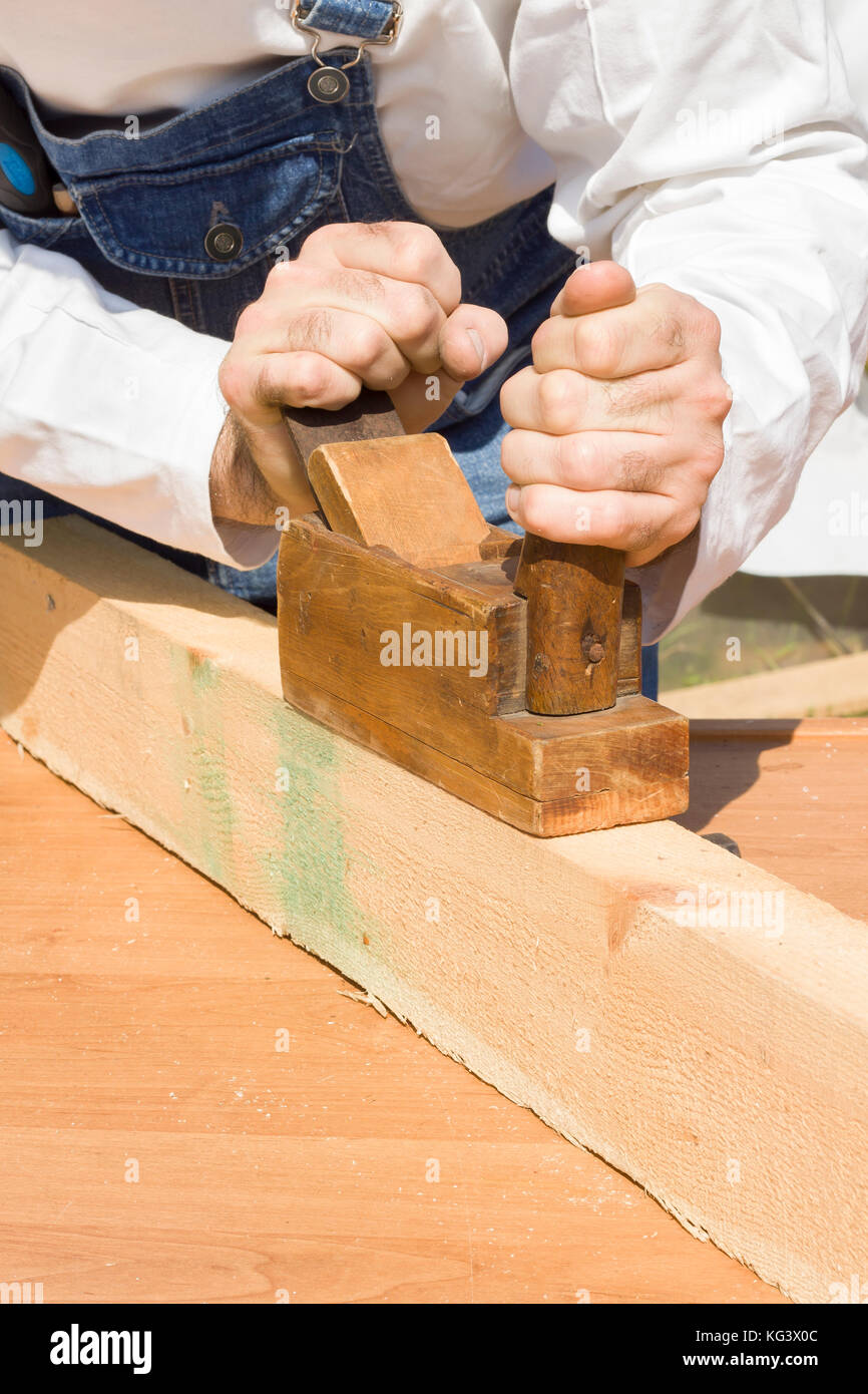 The construction worker boards the timber through a manual plane. Hand ...