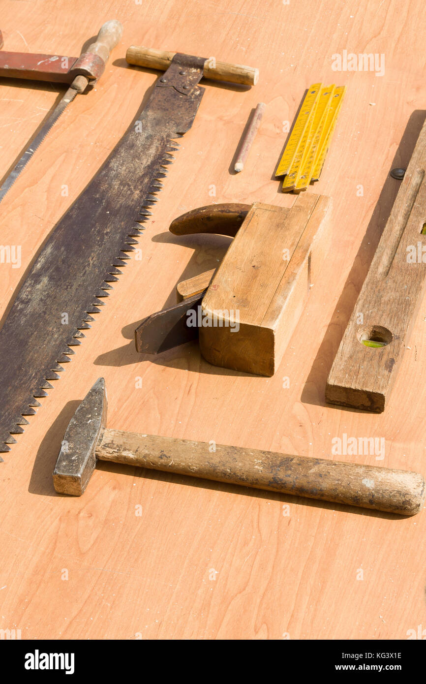 Old carpenter tools lie on the table. plane, saw, level, scoop, hammer ...