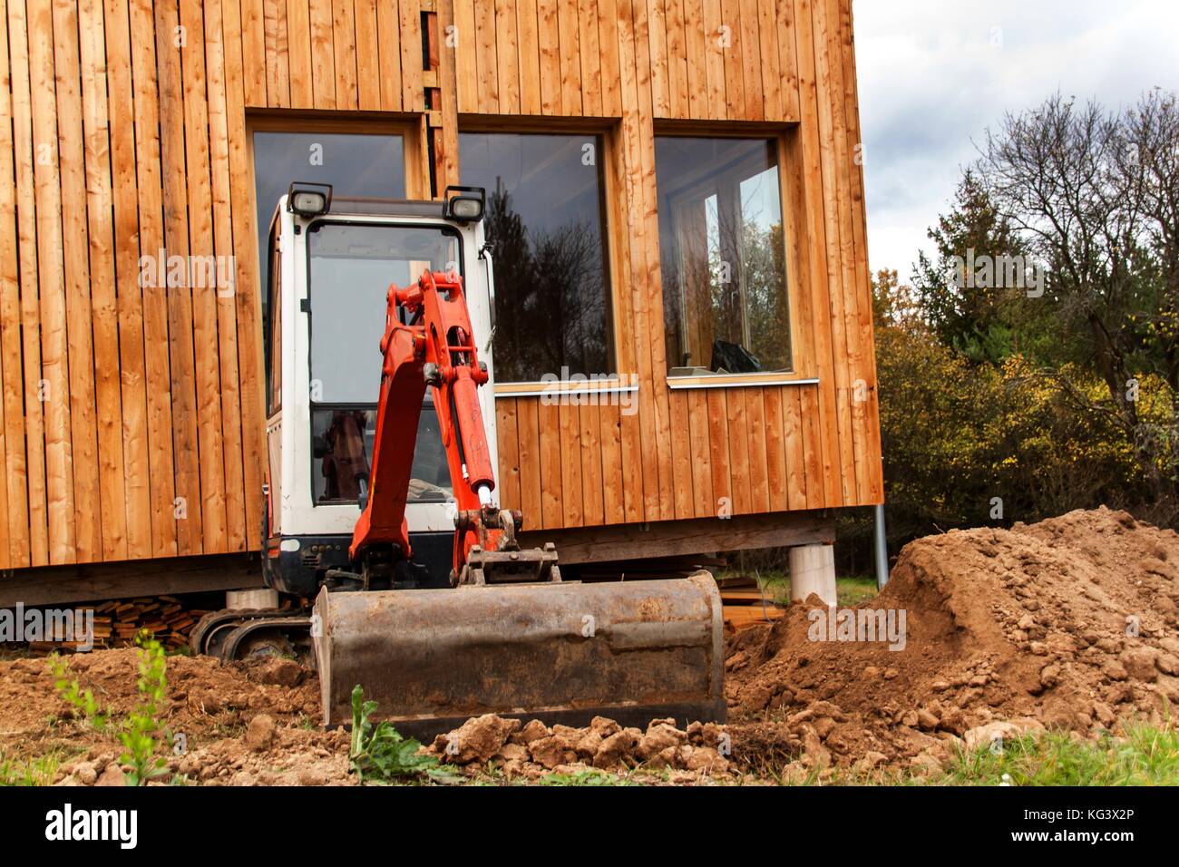 Work on the construction site of an ecological house. The excavator ...